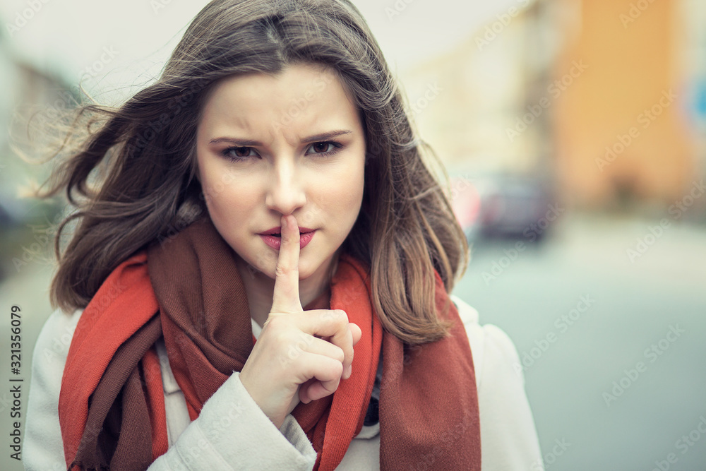Shh Woman wide eyed asking for silence or secrecy with finger on lips ...