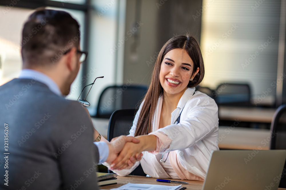 Doctor greeting a patient. Happy female brunette doctor at medical ...