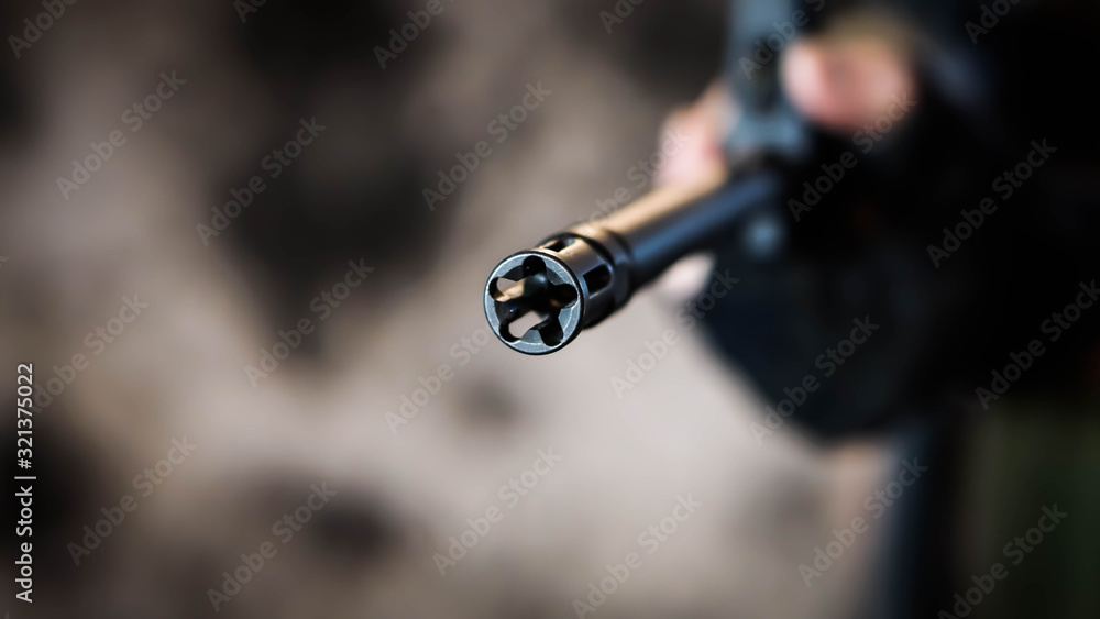 Armed security contractor holds barrel of an AR15 rifle to the camera ...