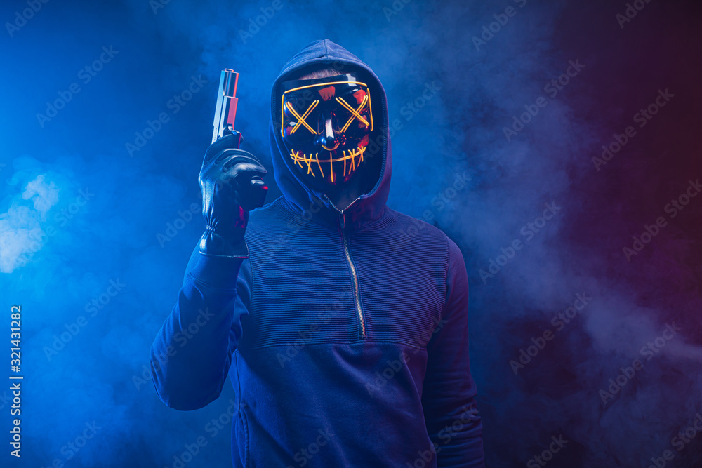 confident dangerous killer male in pullover stand in the hood with gun ...