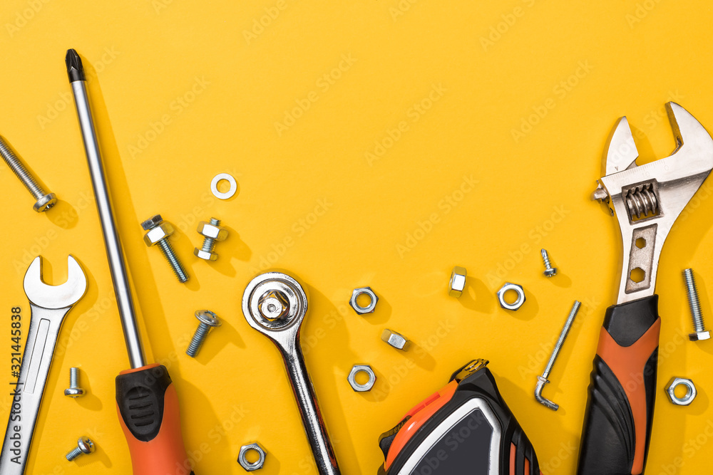 Top view of tool set with nuts and bolts on yellow background Stock ...