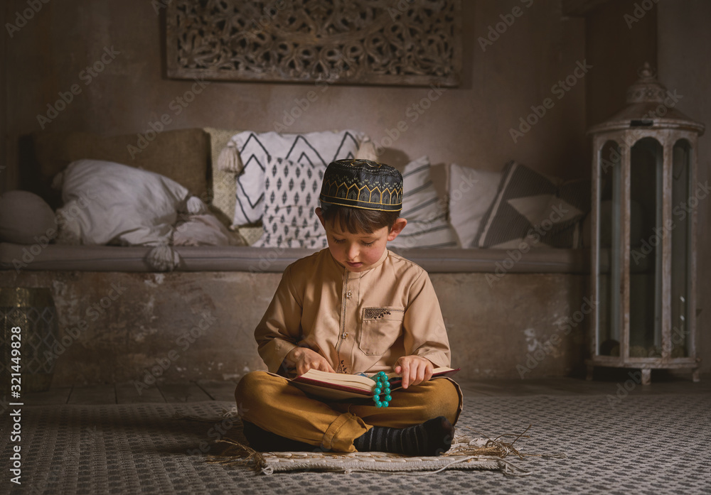 Young muslim boy in prayer cap and arabic clothes with rosary beads ...