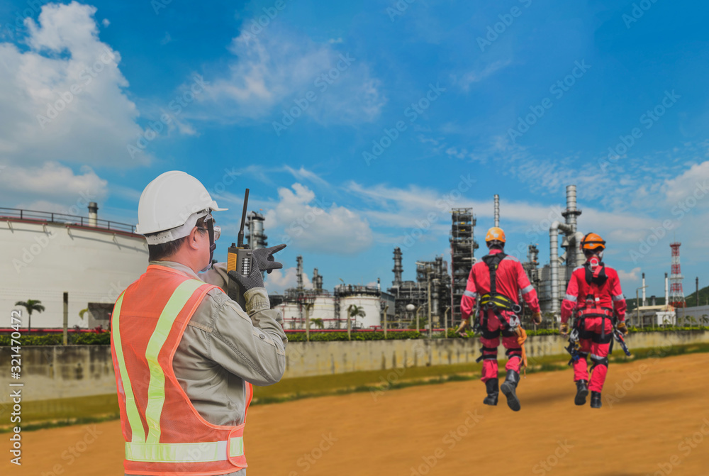 worker with walkies talkie by hand pointing operate control in oil ...