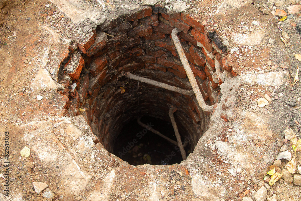 Deep old well with metal ladder Stock Photo | Adobe Stock