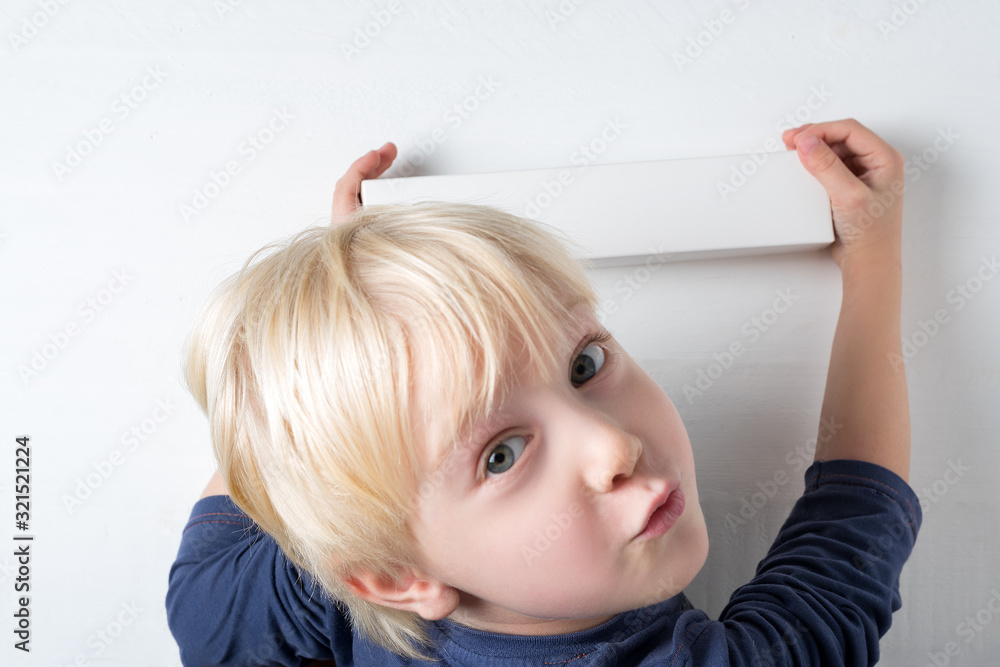 Child holds box in hands on white background. Cute little boy is happy ...