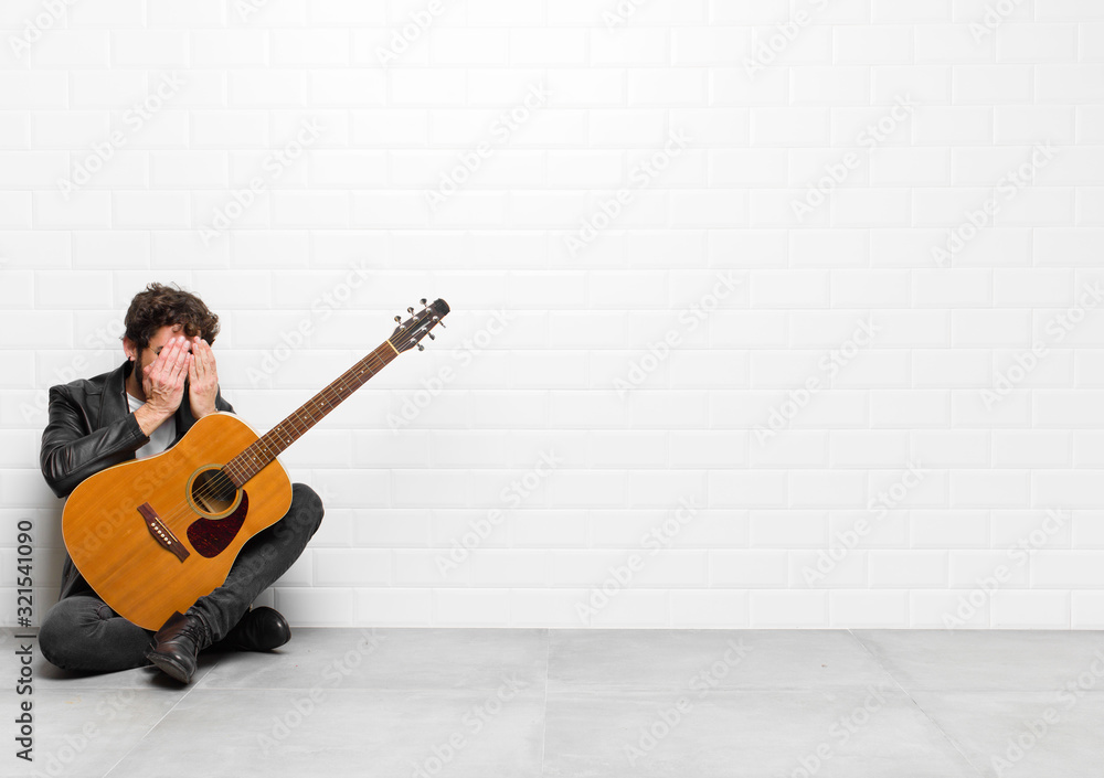 young musician man feeling sad, frustrated, nervous and depressed ...
