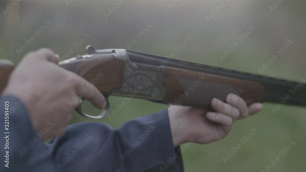 Close up of someone firing an over under double barrel shotgun, and ...