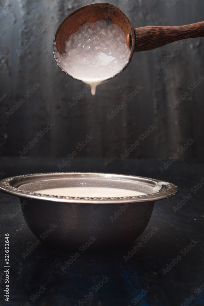 pancake batter being mixed with a wooden ladle, fermented rice pancake ...