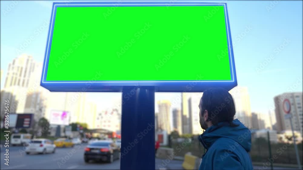 Green screen billboard on urban, street traffic. Cars are going and ...