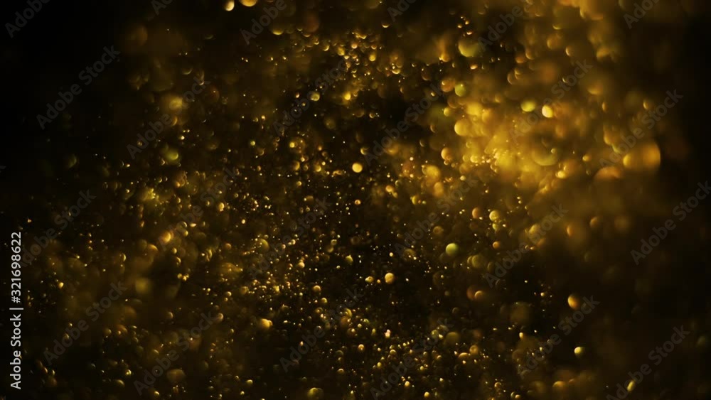 Golden glitter background in slow motion. Beautiful transition with real gold particles flying ...