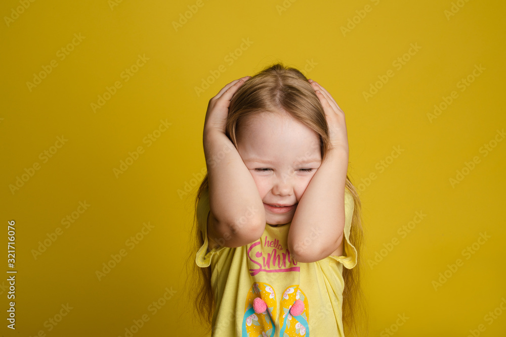 Portrait of scared little girl closing head by hands posing isolated at ...