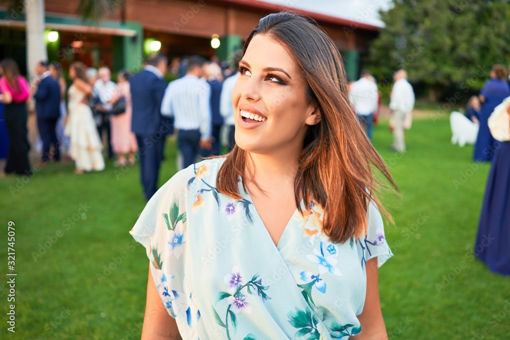 Young beautiful and elegant woman with wedding guest dress smiling ...
