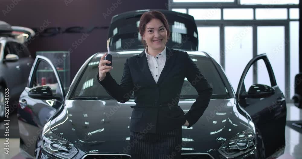 Positive adult Caucasian woman posing with car keys in front of new ...