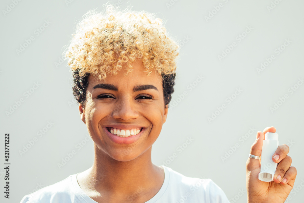 africa american woman using asthma inhaler in the studio white ...