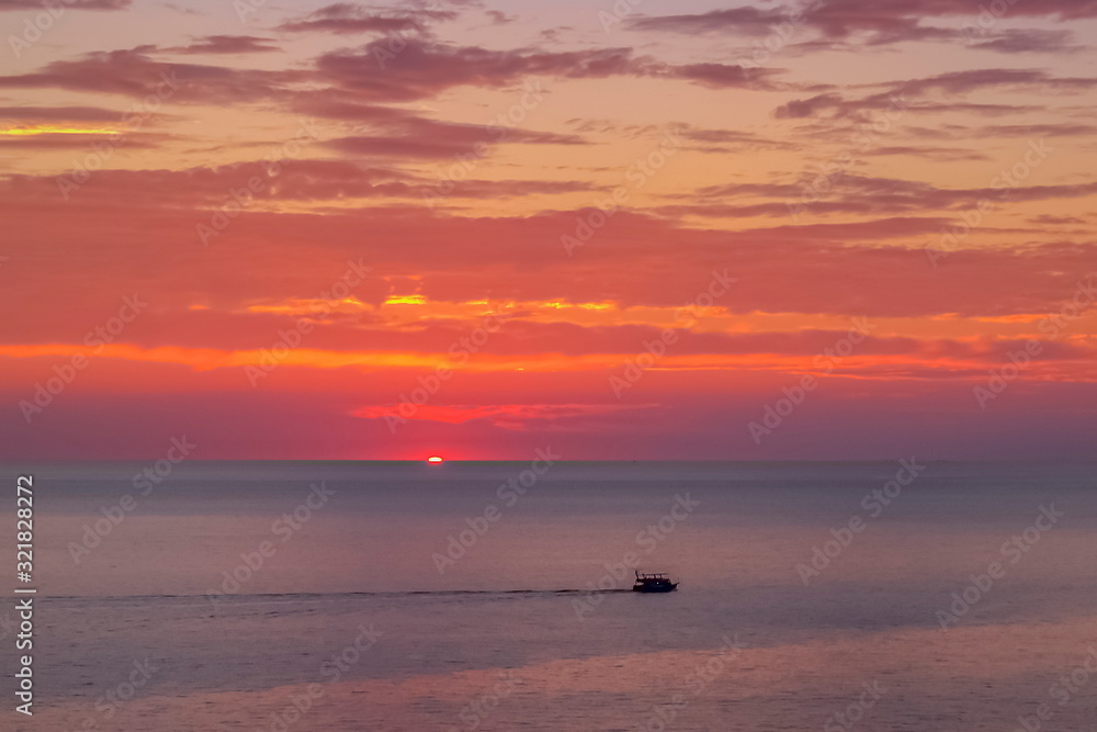 view seaside evening of many clouds moving above the sea with red sun ...