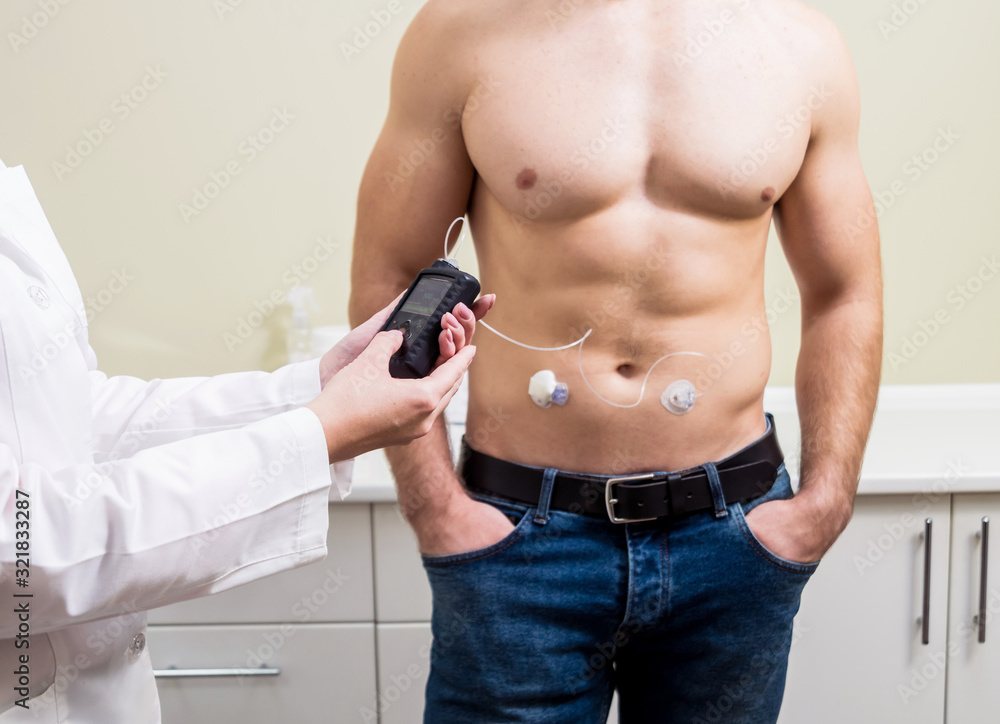 The doctor connects an insulin pump to a patient with diabetes. Stock ...