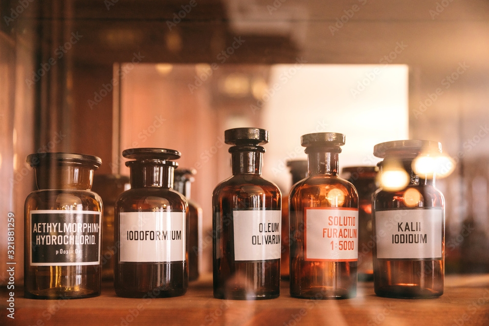 Dark glass potion bottles with medicines in an old pharmacy in a wooden ...