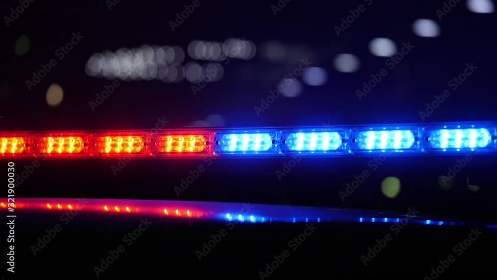 Footage of a crime scene and a police car with emergency lights turned ...