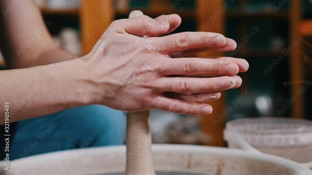 Pottery craftsmanship - a man's hands forming piece of clay in longer ...