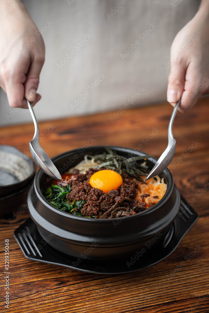 mixing korean famouse hot stone bowl bibimbap Stock Photo | Adobe Stock
