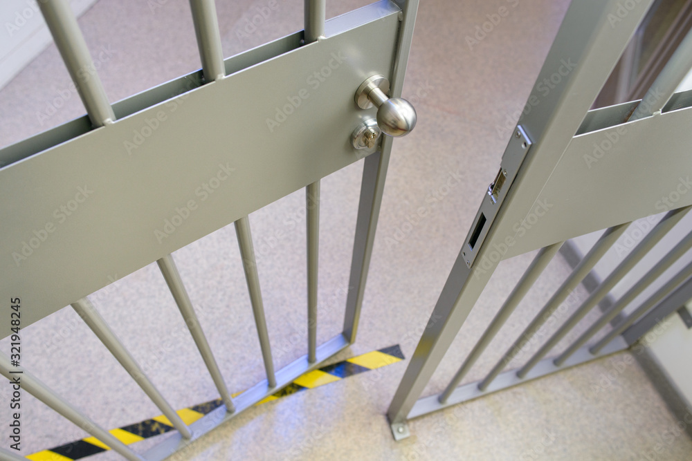Metal bars in prison. Opened jail cell door. The lock and steel bobble ...