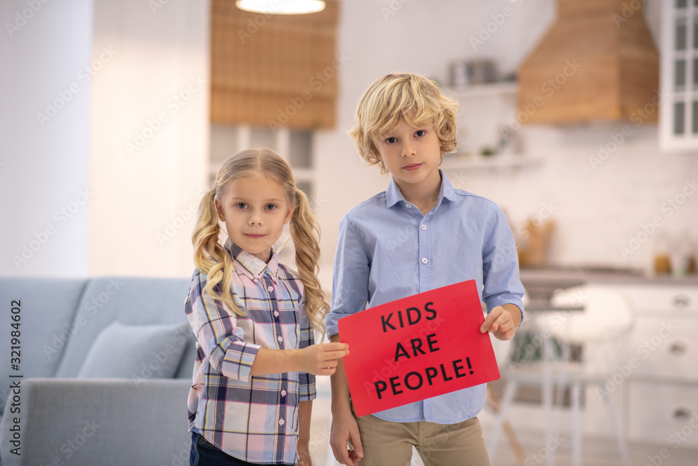 Kids standing next to each other, holding sign Stock Photo | Adobe Stock