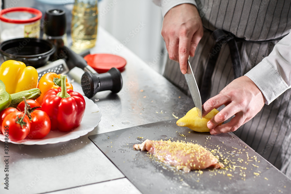 Chief chops and marinates chicken. Professional chef in a kitchen of ...