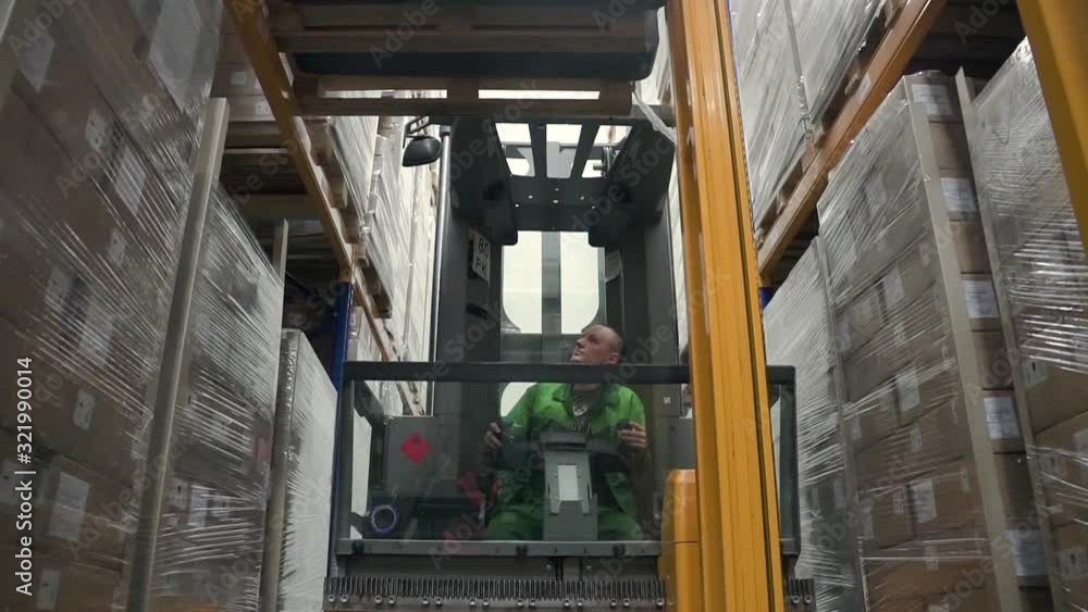 Warehouse man worker with forklift. loader loading goods at shelves ...