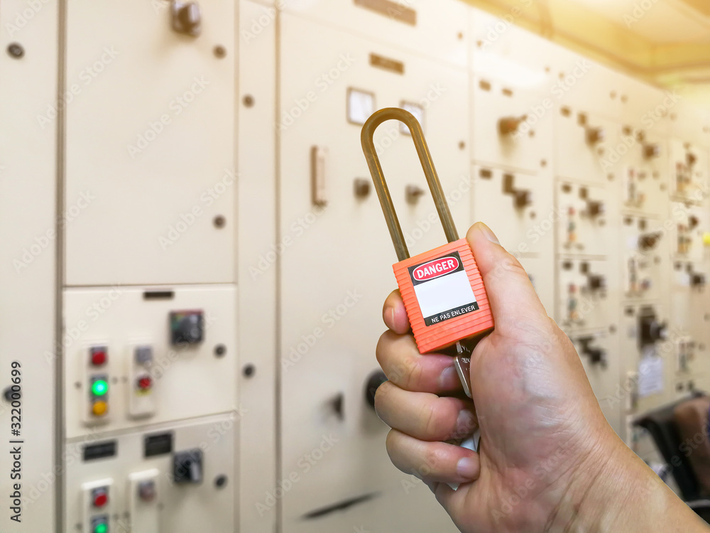 Foto de Hand holding red key lock and tag for process cut off ...