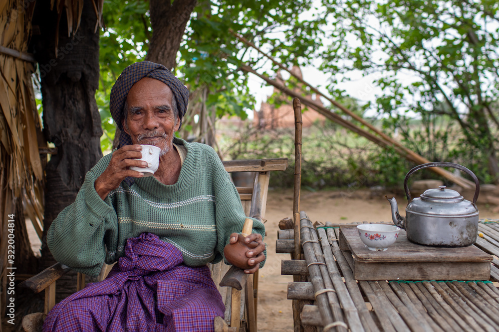 Burmese man relaxing outside home Stock Photo | Adobe Stock