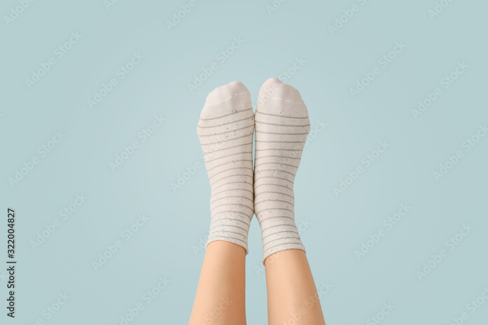 Legs of young woman in socks on color background Stock Photo | Adobe Stock