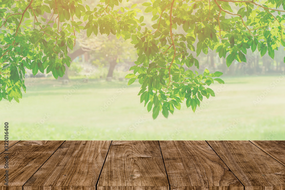 Wood table top on blur abstract green tree garden in the morning ...