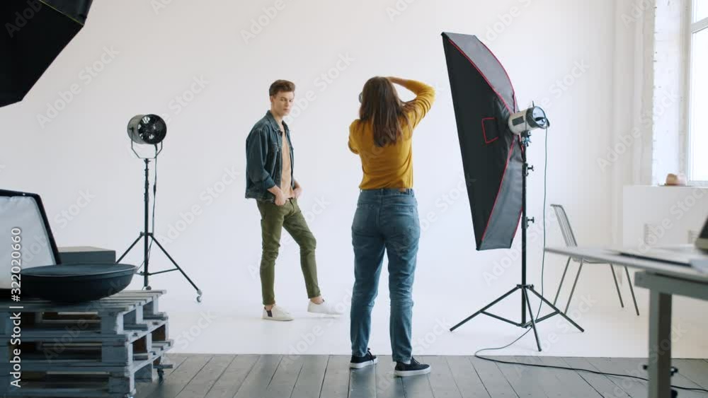 Female photographer is showing body positions to male model working in ...