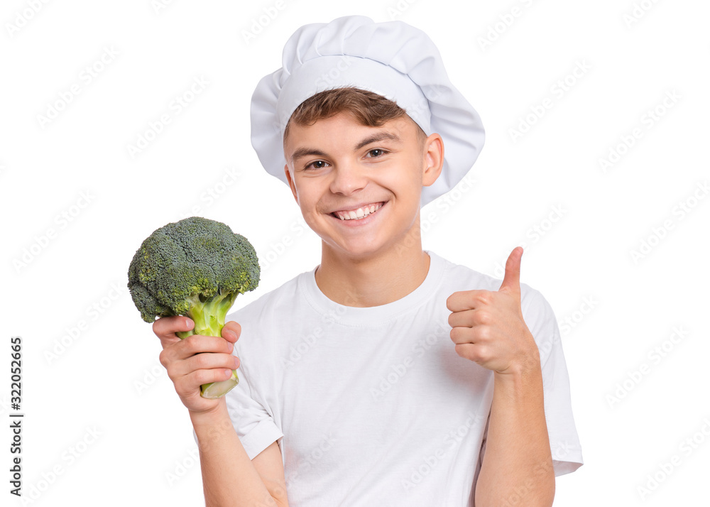 Happy teen boy in chef hat holds fresh green broccoli and making thumb ...
