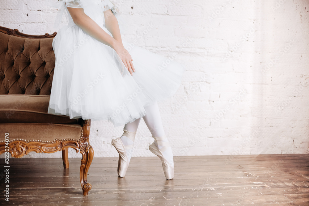 Ballet dancer's feet on studio floor. Teenage dancer puts on ballet ...