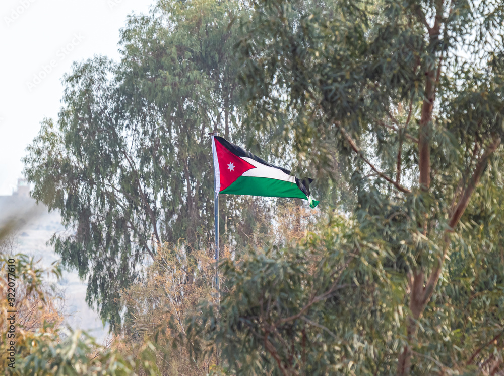 Jordanian flag flies in the wind on the Jordanian part of the Baptismal ...
