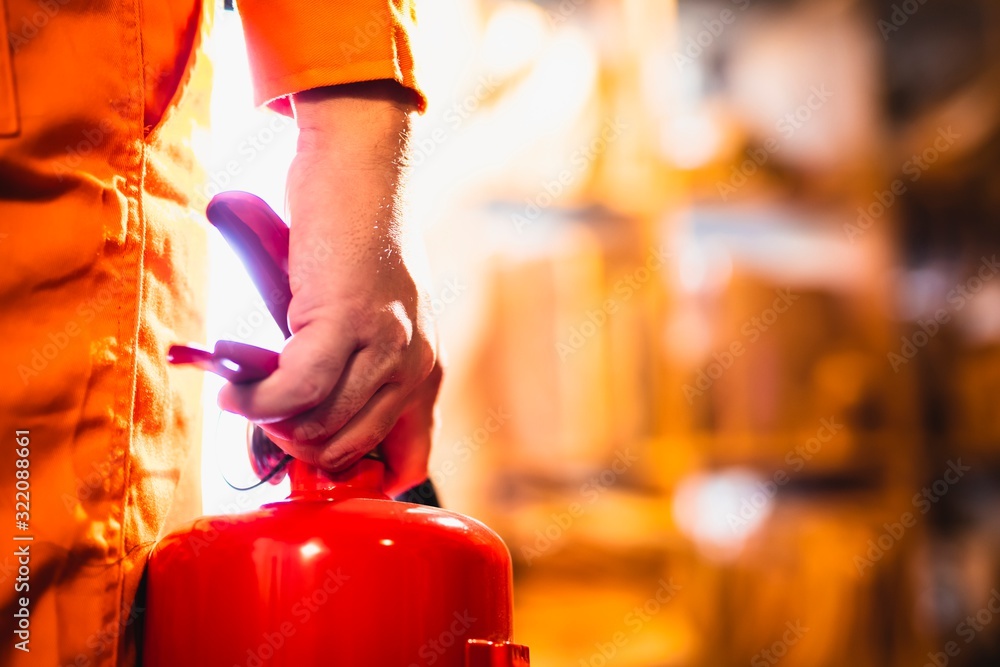 Man using fire extinguisher fighting fire closeup Stock Photo | Adobe Stock