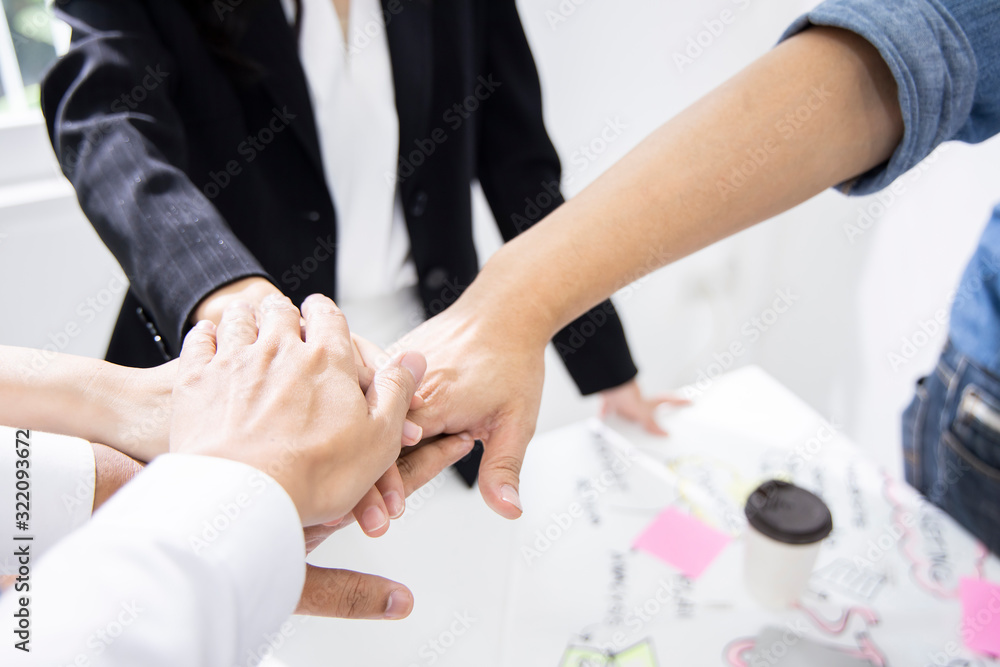 Colleagues are gathering hands to encourage each other to work. For ...