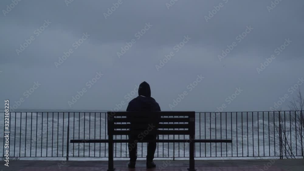 The man looks at the raging sea. A man is watching the storm ...