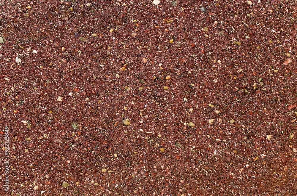 smooth surface of colored concrete slab with visible stones of various ...
