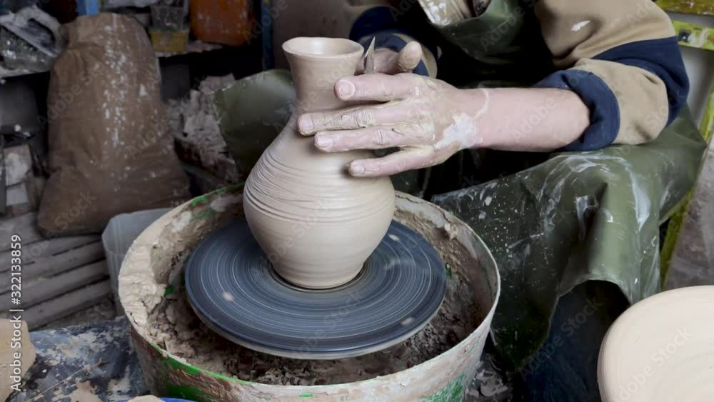 Hands of a potter on a pottery wheel close-up. Old traditional art ...