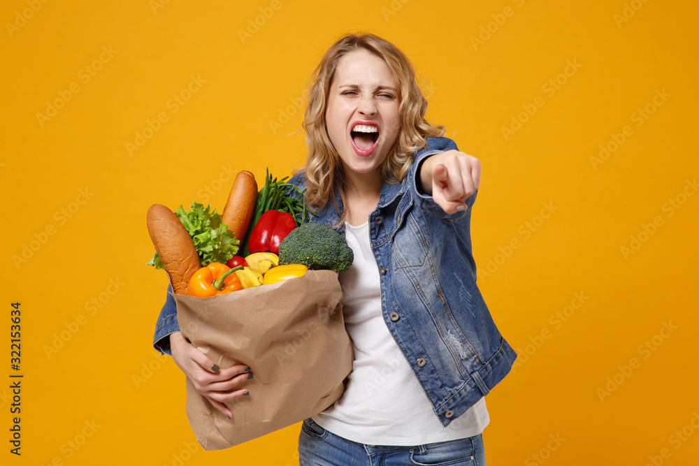 Angry girl in denim clothes isolated on orange background. Delivery ...