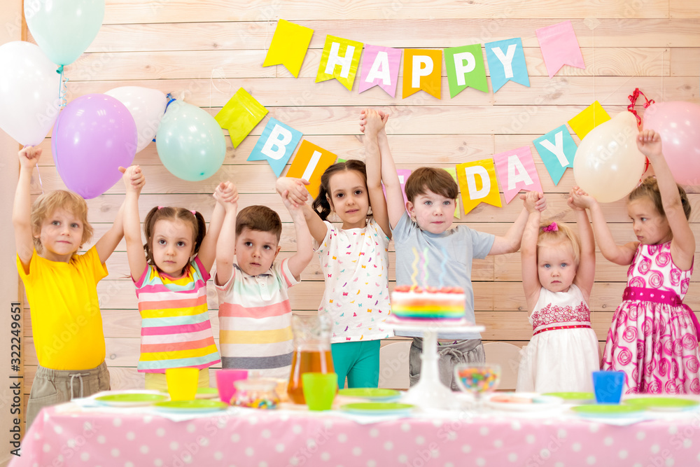 Large group of preschool children happily hold their hands up. Kids ...