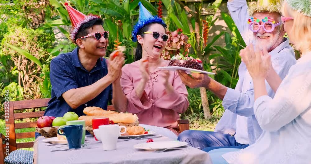 Senior man birthday outdoor, blowing candle and clapping. Big family ...