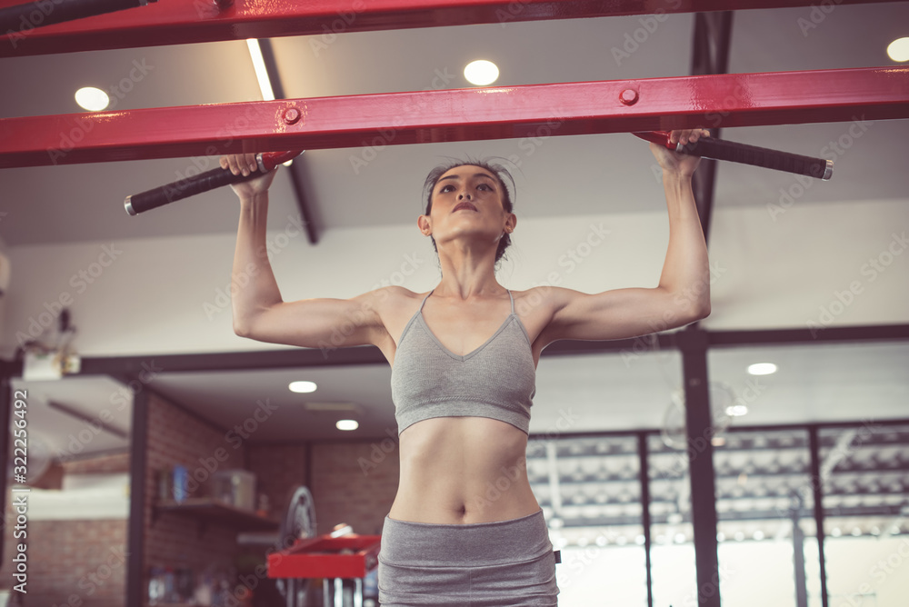 female adults doing pull ups on bar in cross fit training gym. photo of ...