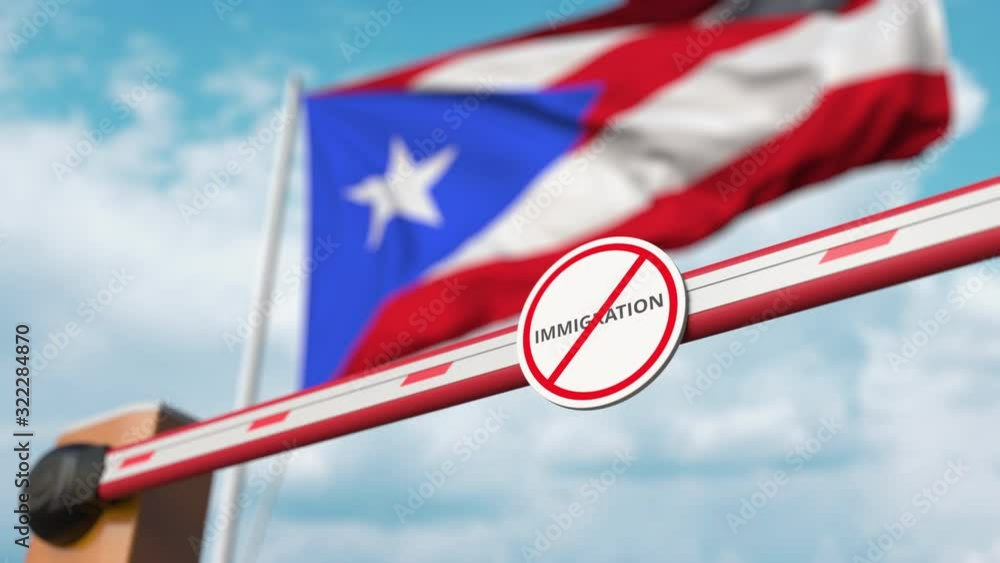 Closing boom barrier with stop immigration sign against the Puerto ...