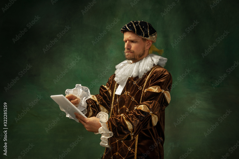 That's technology. Portrait of medieval young man in vintage clothing ...