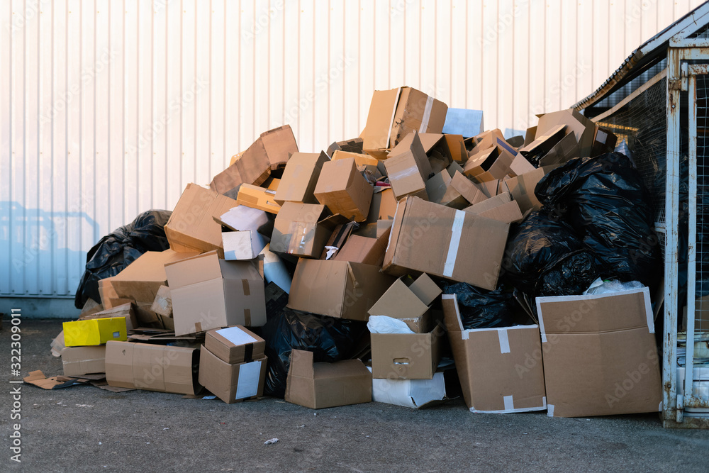Paper boxes next to a garbage bin. Stack of paper waste outdoor in the ...