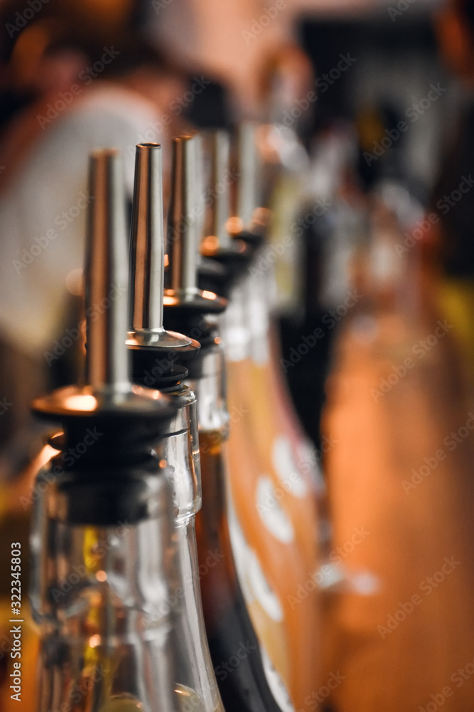 Closeup array of glass bottles with dozers or dispensers for pouring ...
