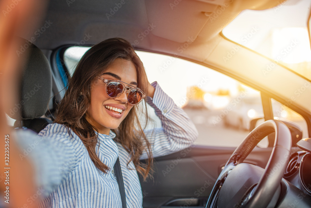 Young smiling womanwith sunglasses making self portrait sitting in the ...